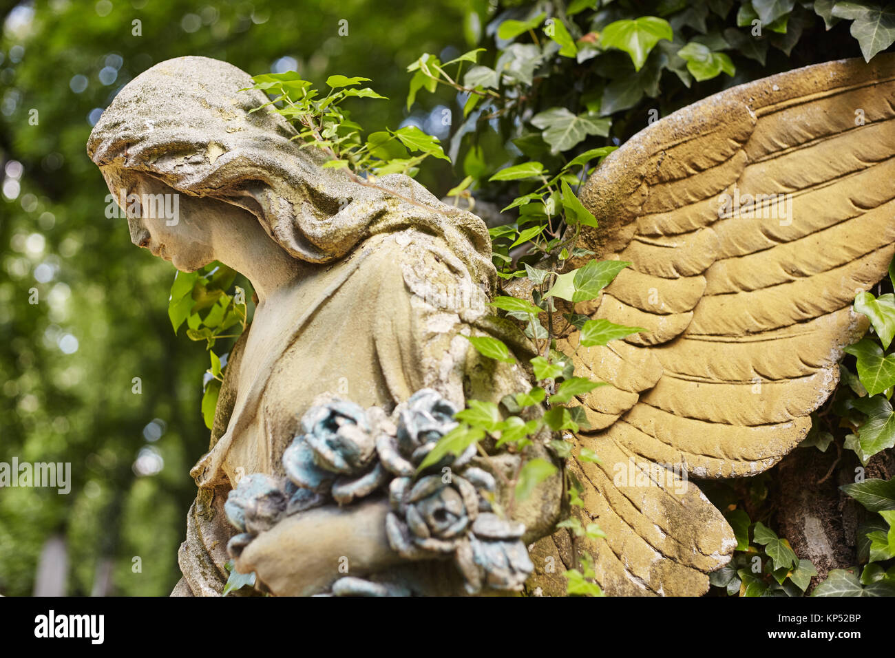 A fragment of ancient sculpture angel in a golden glow in the old ...