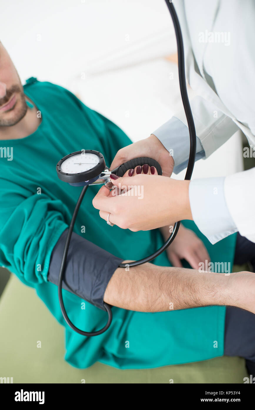 Female doctor checking blood pressure of a patient at clinic Stock ...