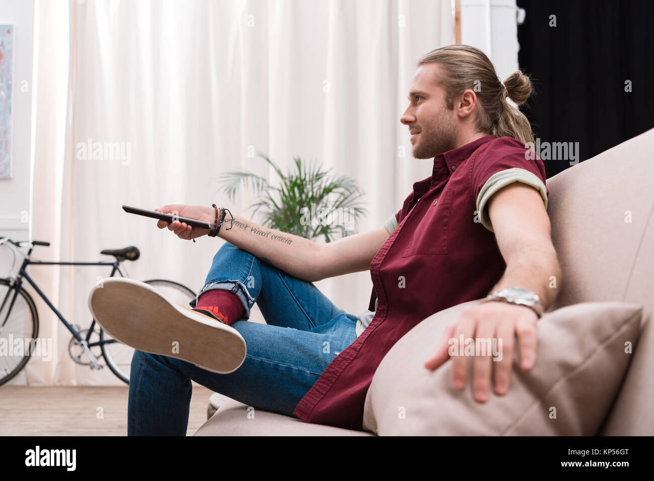 handsome man with remote control watching tv at home Stock Photo - Alamy