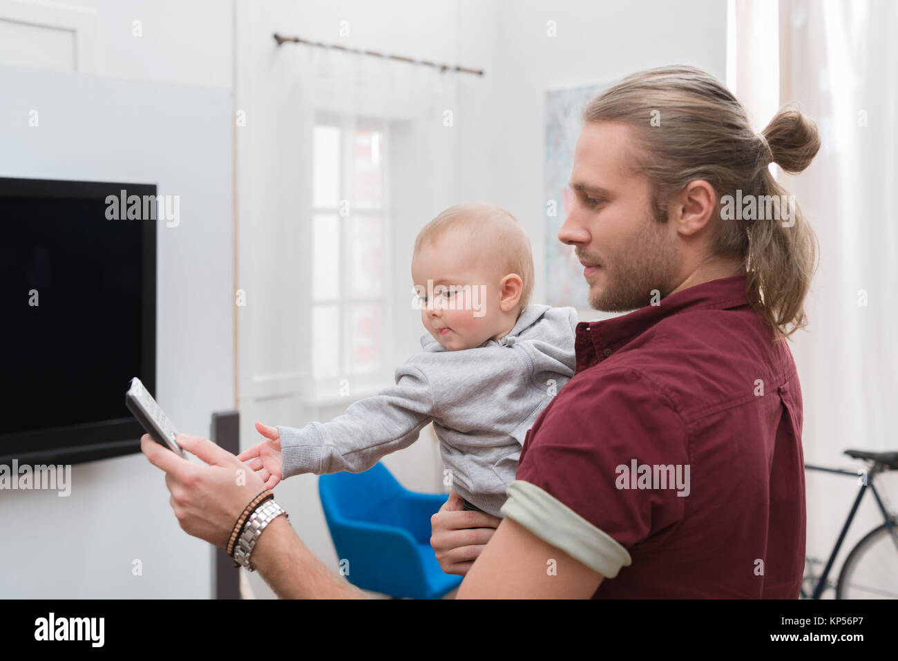 father watching TV with little baby boy at home Stock Photo - Alamy