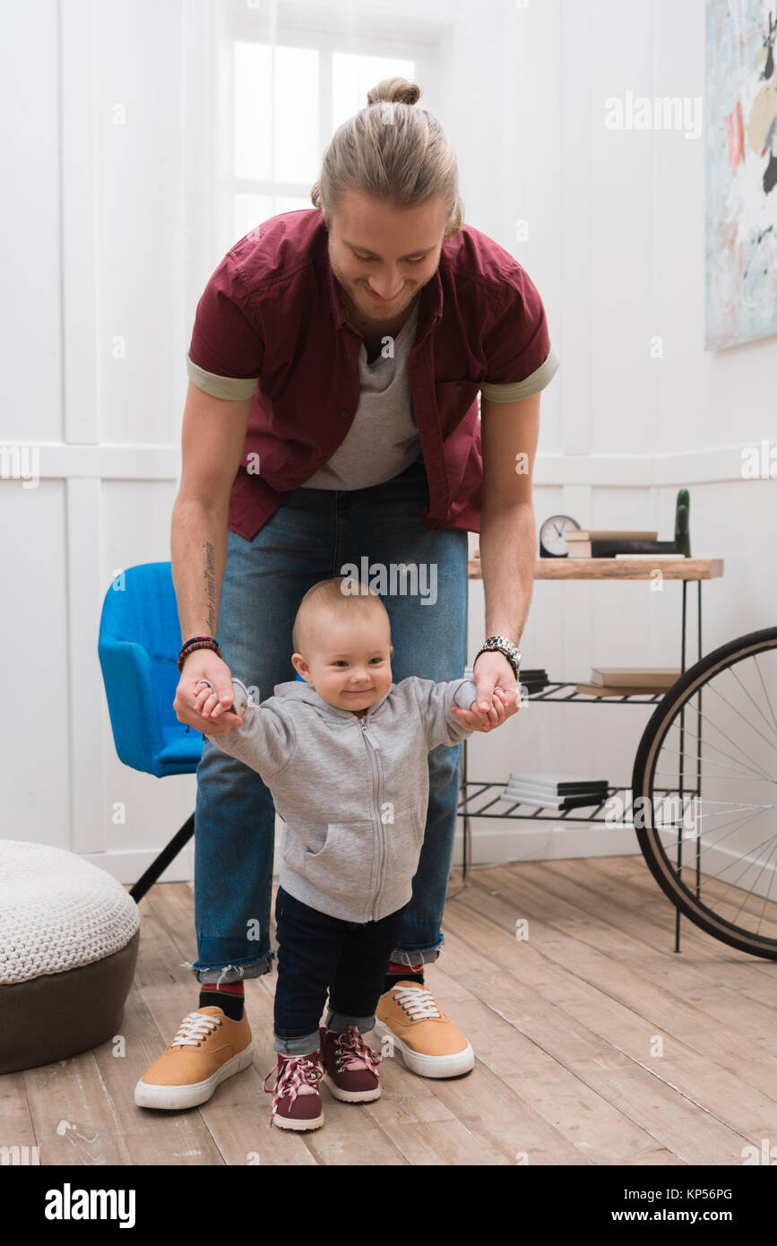 cheerful father teaching baby boy to walk at home Stock Photo - Alamy