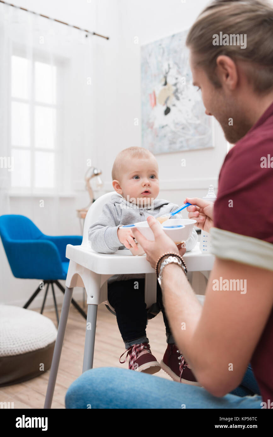 daddy feeding his little son with baby food at home Stock Photo - Alamy