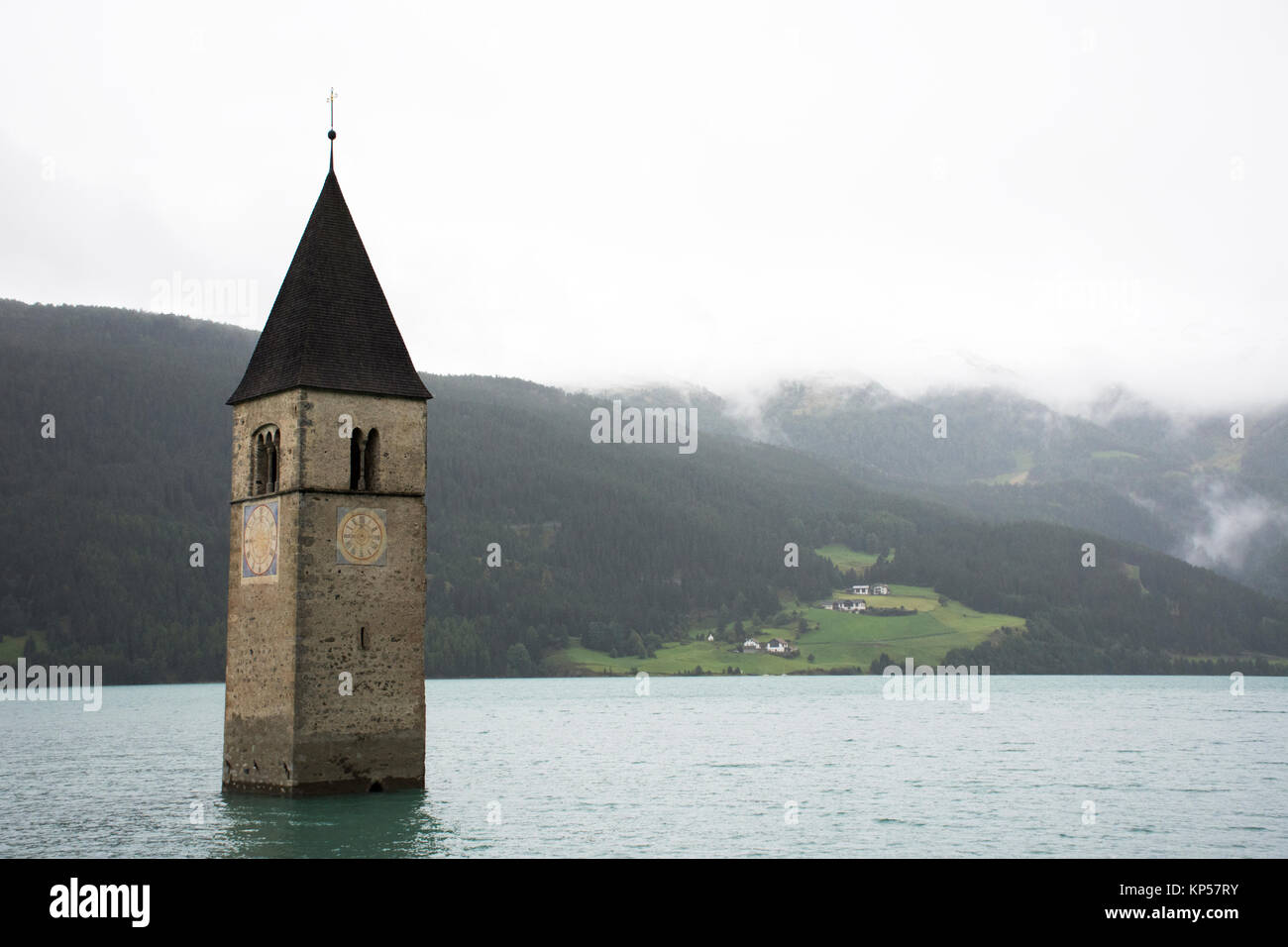 Submerged tower of reschensee church deep in Resias Lake while raining ...