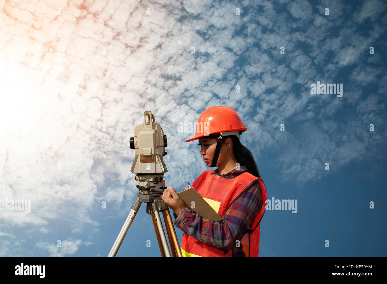 Female Surveyor or Engineer making measure by Theodolite on the field ...