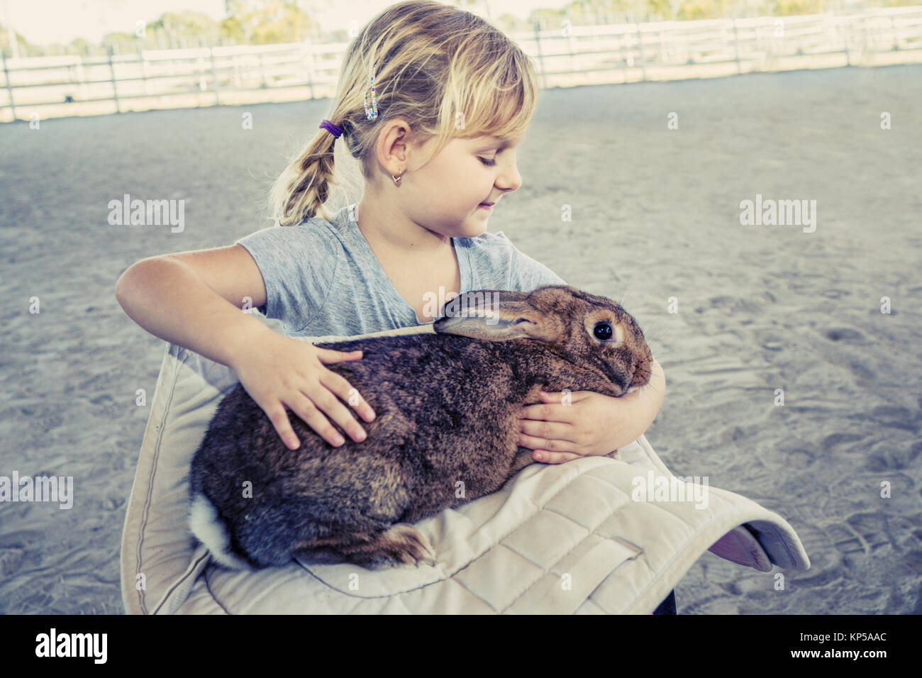 Beautiful little girl holding a rabbit in her arms Stock Photo - Alamy
