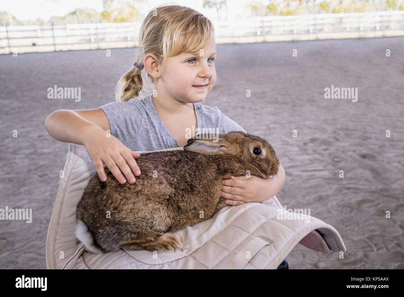 Beautiful little girl holding a rabbit in her arms Stock Photo - Alamy