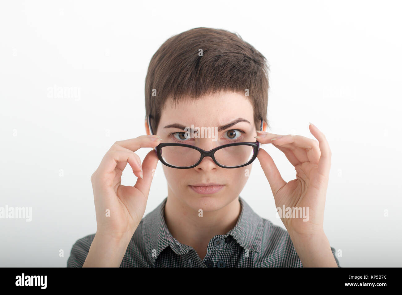 Businesswoman looking sternly over her glasses. Portrait of fashionable ...