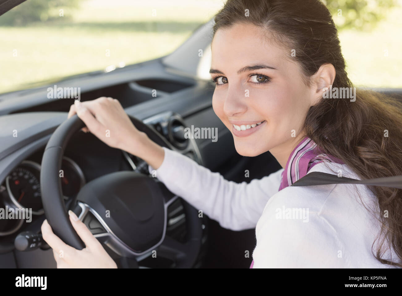 Young beautiful woman driving her car, she is holding the steering ...