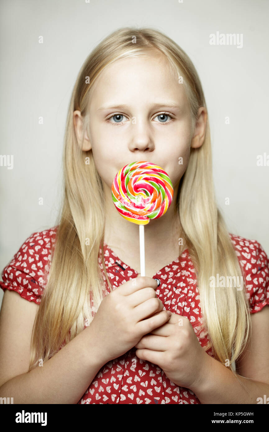 Beautiful young girl with candy, funny face Stock Photo - Alamy