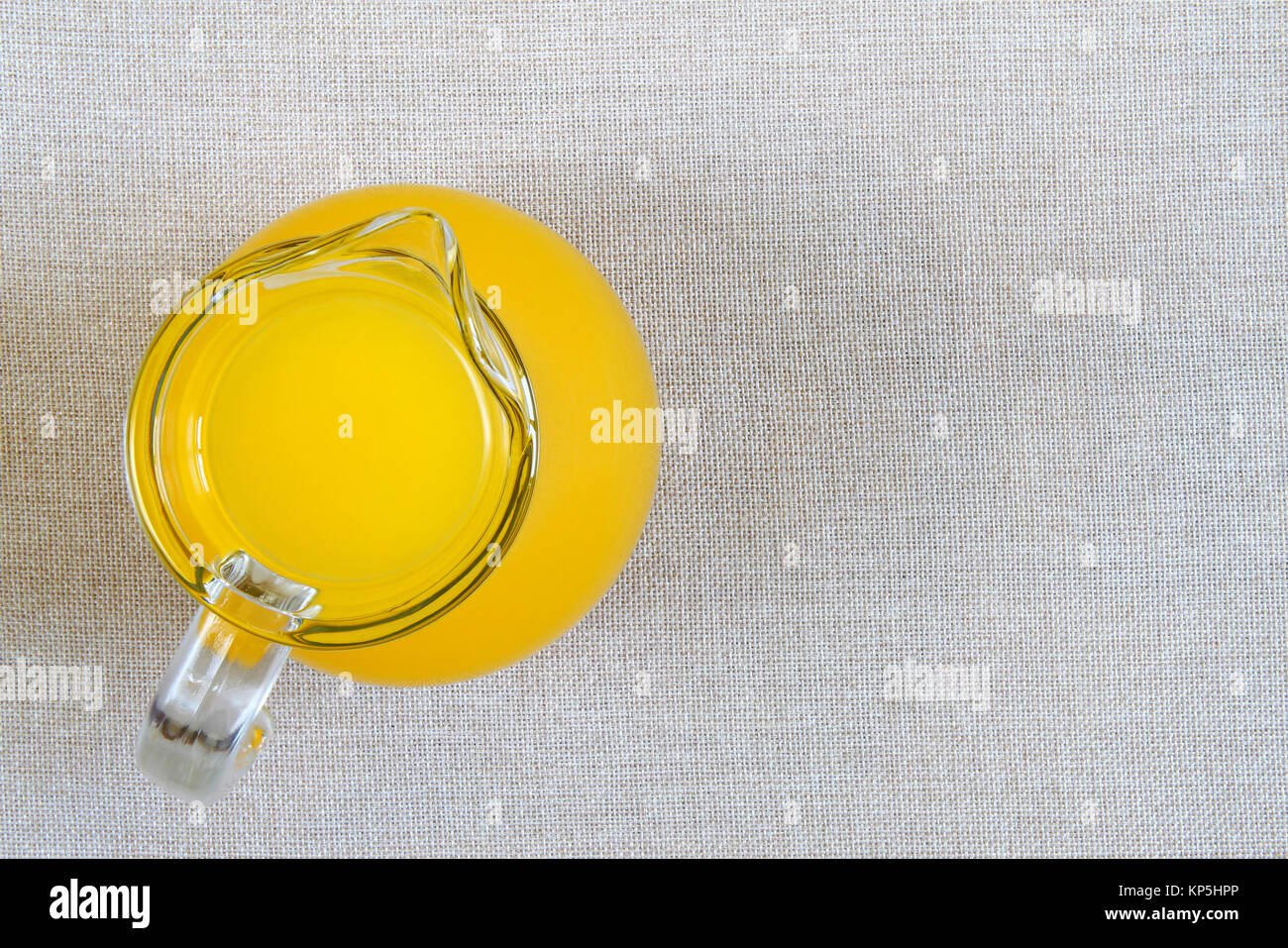 Jug and glass of orange juice from above, top view on burlap sackcloth ...