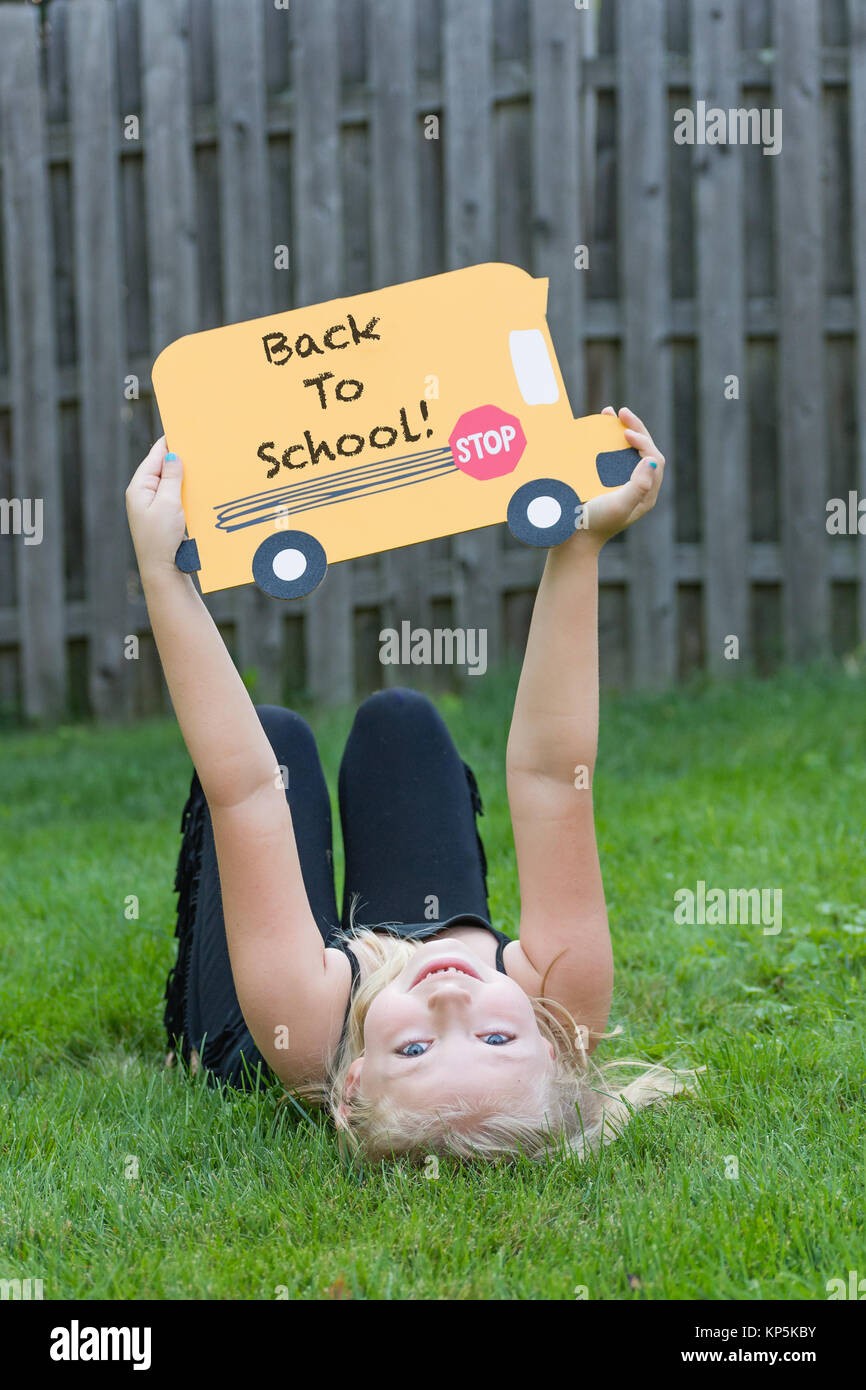 adorable school age girl holding back to school sign for first day of ...