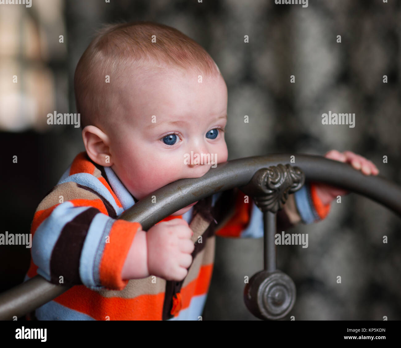 A young boy props himself up on the metal bed frame Stock Photo - Alamy