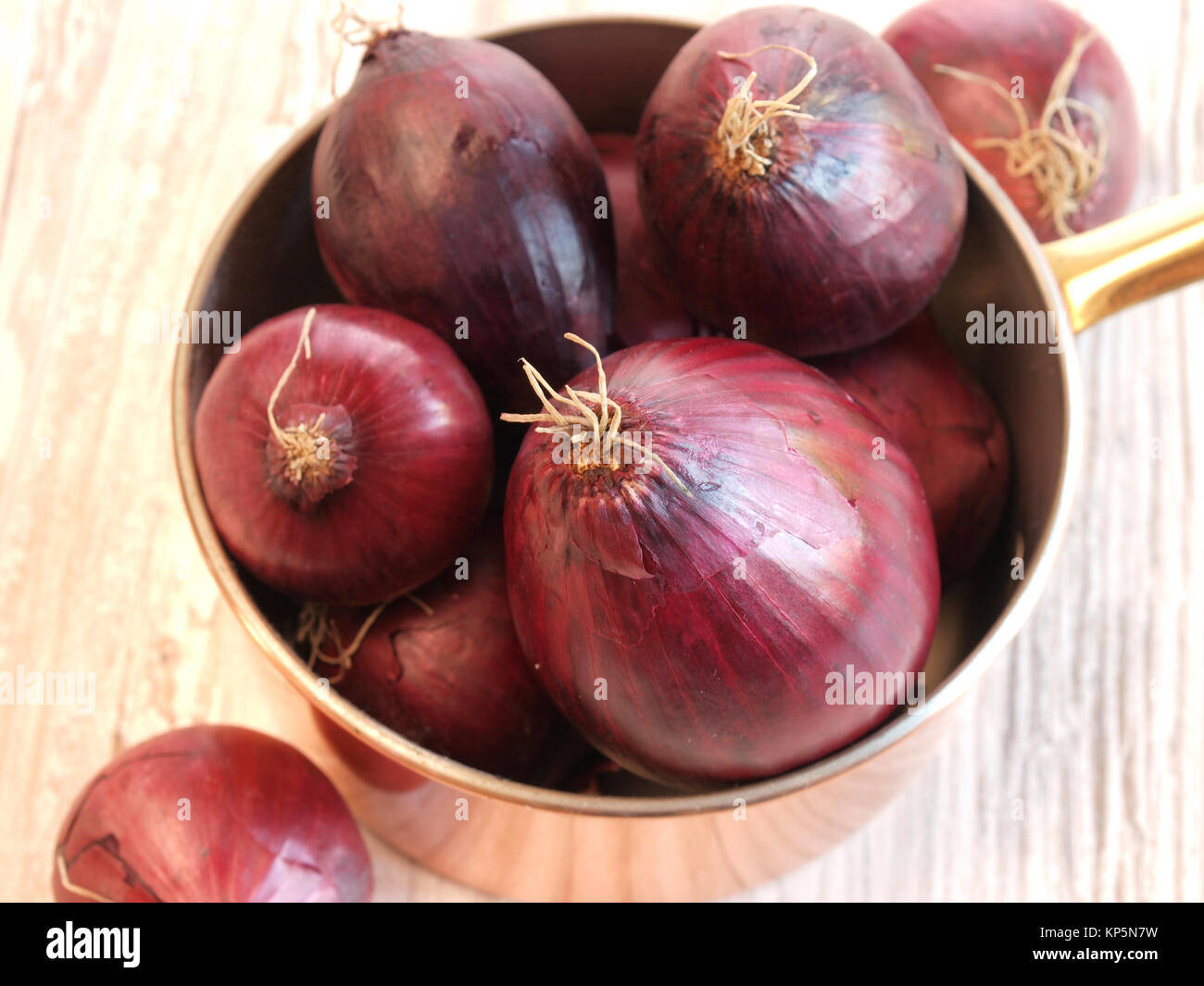 Fresh red onions in a copper pan Stock Photo - Alamy
