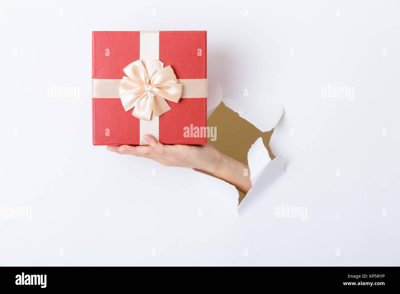 Hand break through paper with red present box Stock Photo - Alamy