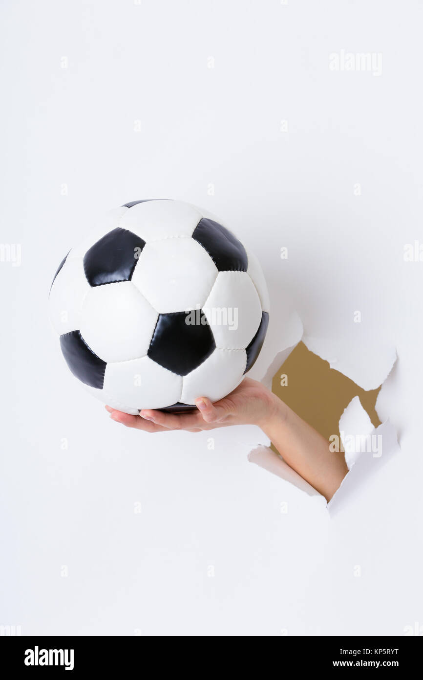 Hand break through paper with soccer ball Stock Photo - Alamy