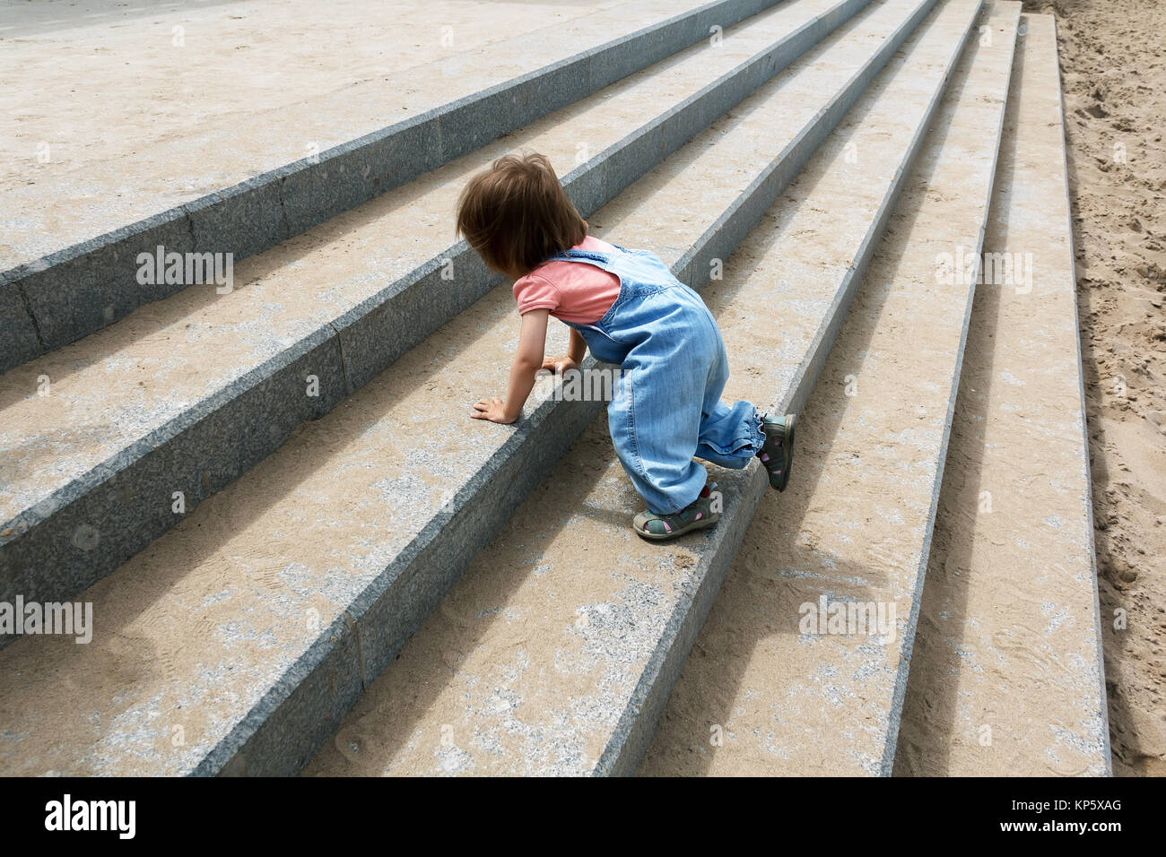 Baby girl in blue cloth creep up on the stairs Stock Photo - Alamy