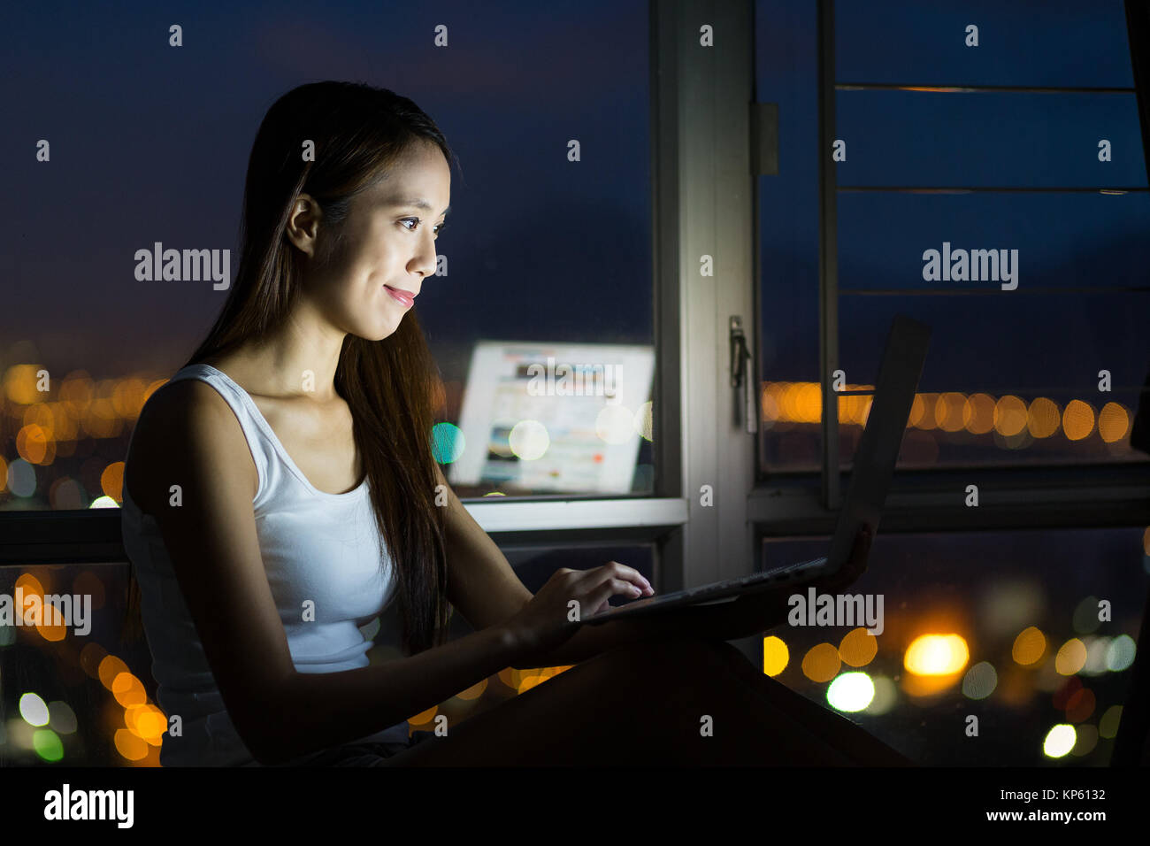 Woman using notebook computer at night Stock Photo - Alamy