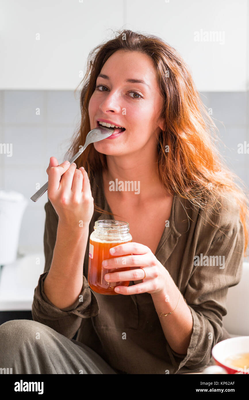 Woman eating honey Stock Photo - Alamy