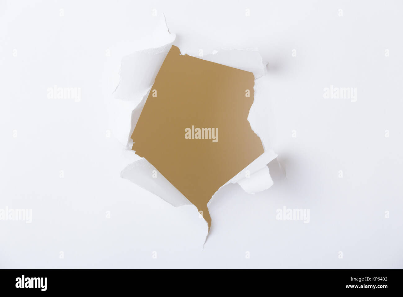 Hole in the paper with torn sides Stock Photo - Alamy