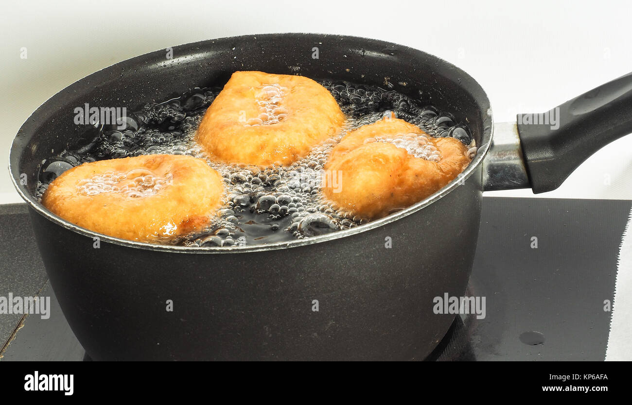 Closeup of donuts cooking in boiling hot oil in kettle Stock Photo - Alamy