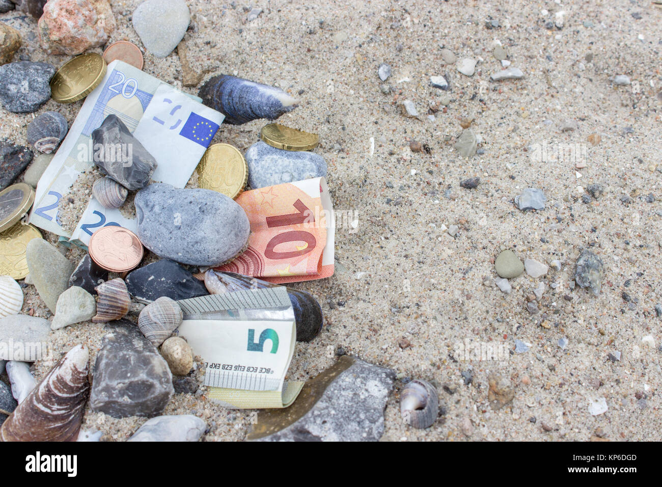 coins,bills,stones and shells in the sand Stock Photo - Alamy