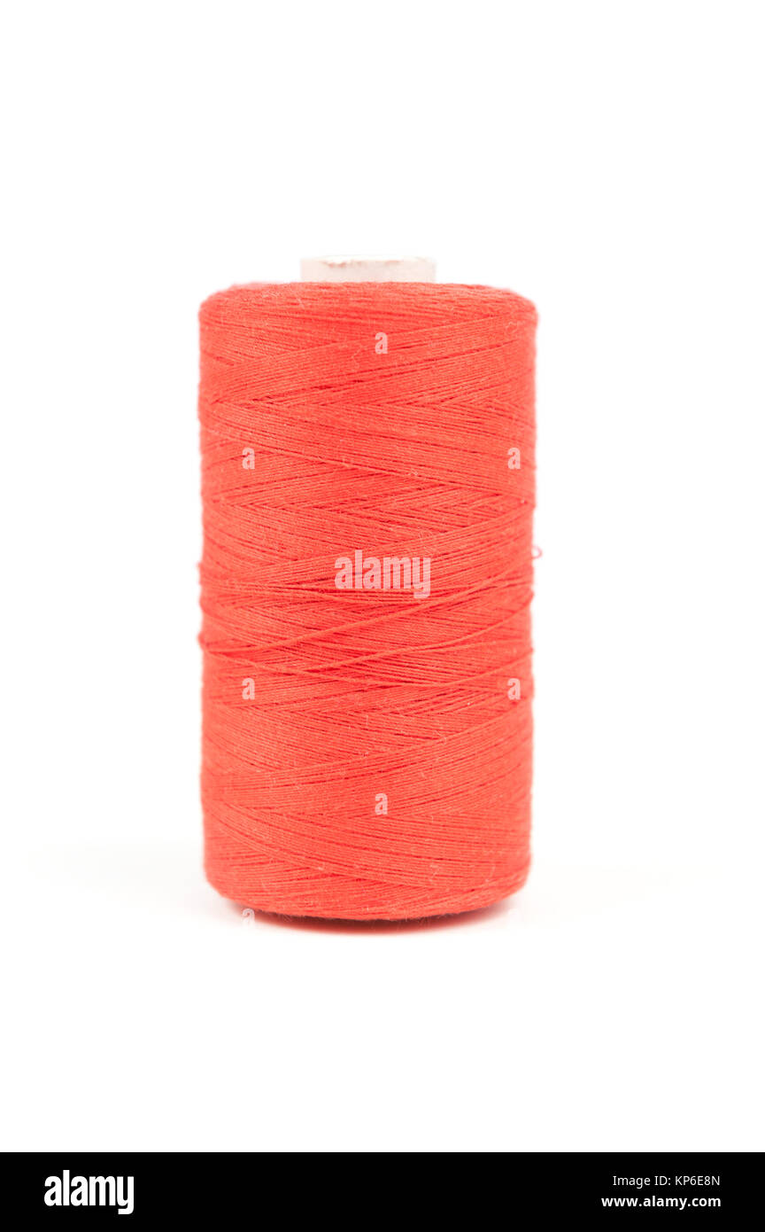Orange spool of thread on white background Stock Photo - Alamy
