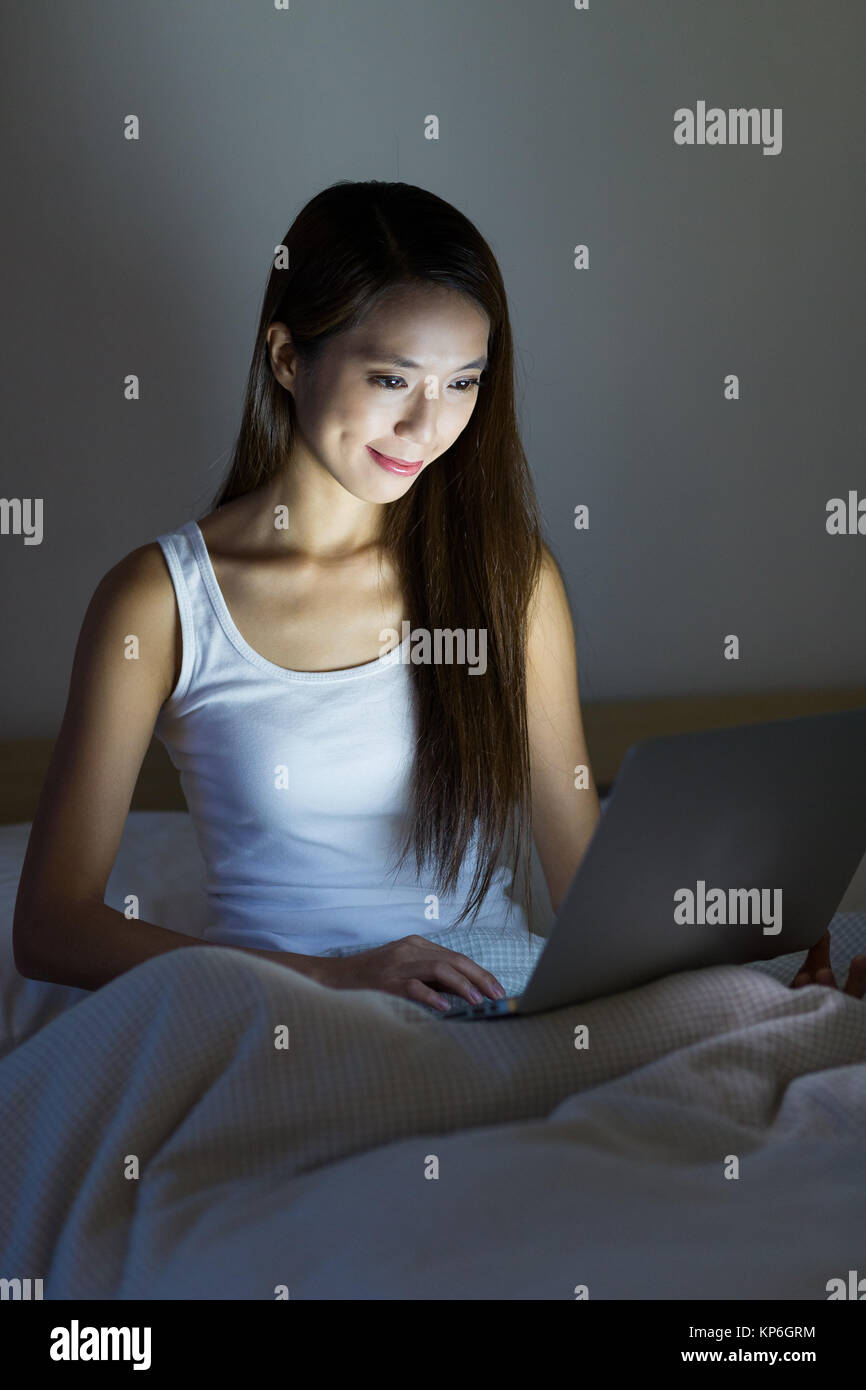 Woman working with laptop computer on bed Stock Photo - Alamy
