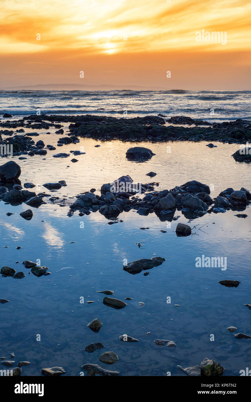 beautiful mellow sunset over rocky beach Stock Photo - Alamy