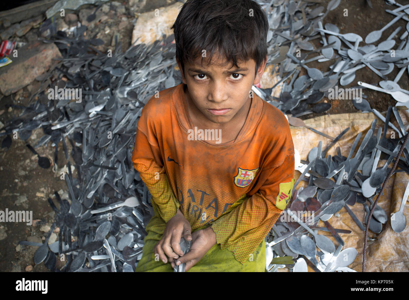 A child labor showing steel spoon Stock Photo - Alamy