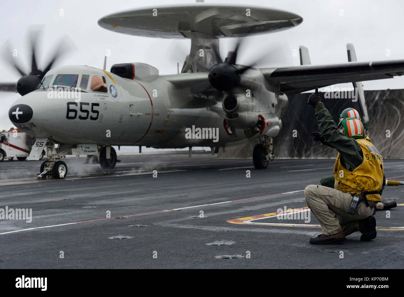 Lt. Jeremiah Anderson signals to launch an E-2C Hawkeye, assigned to ...
