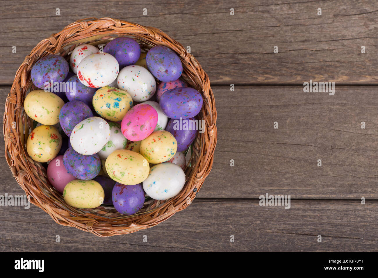 Colorful Easter egg candy in a basket on a wood surface Stock Photo - Alamy