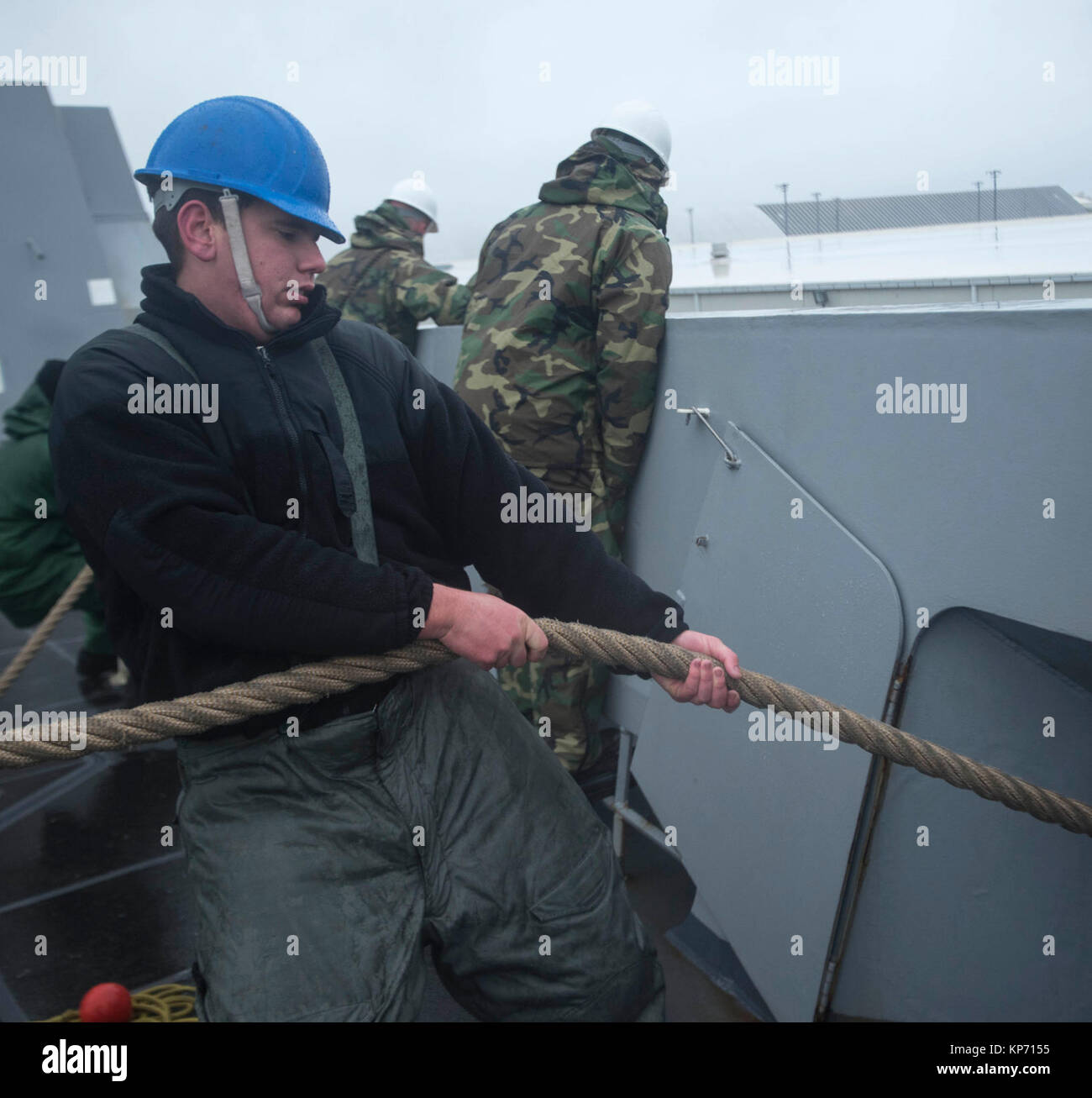 US navy sailor pulls rope Stock Photo - Alamy