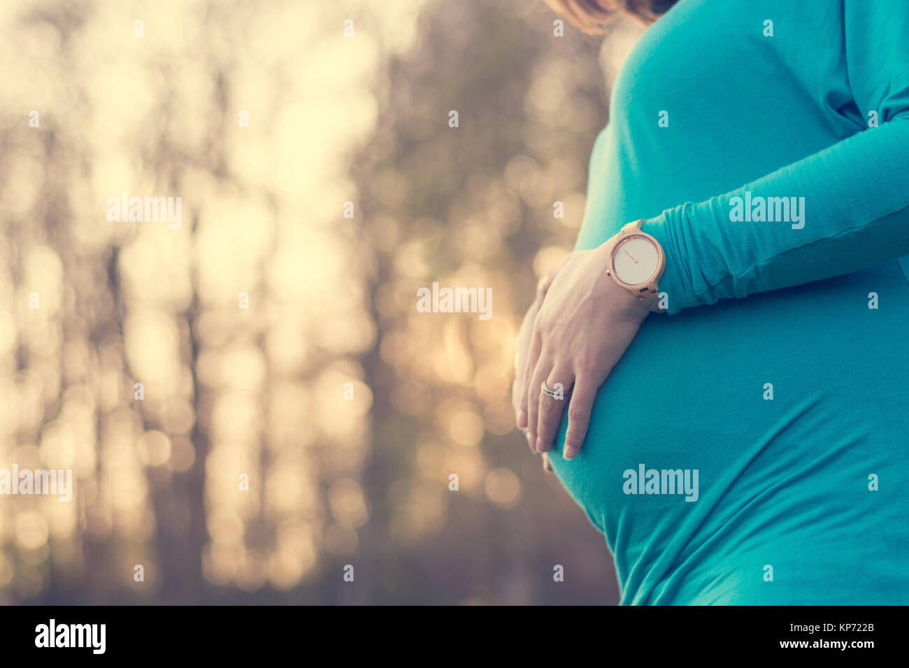 Closeup of pregnant belly at sunset Stock Photo - Alamy