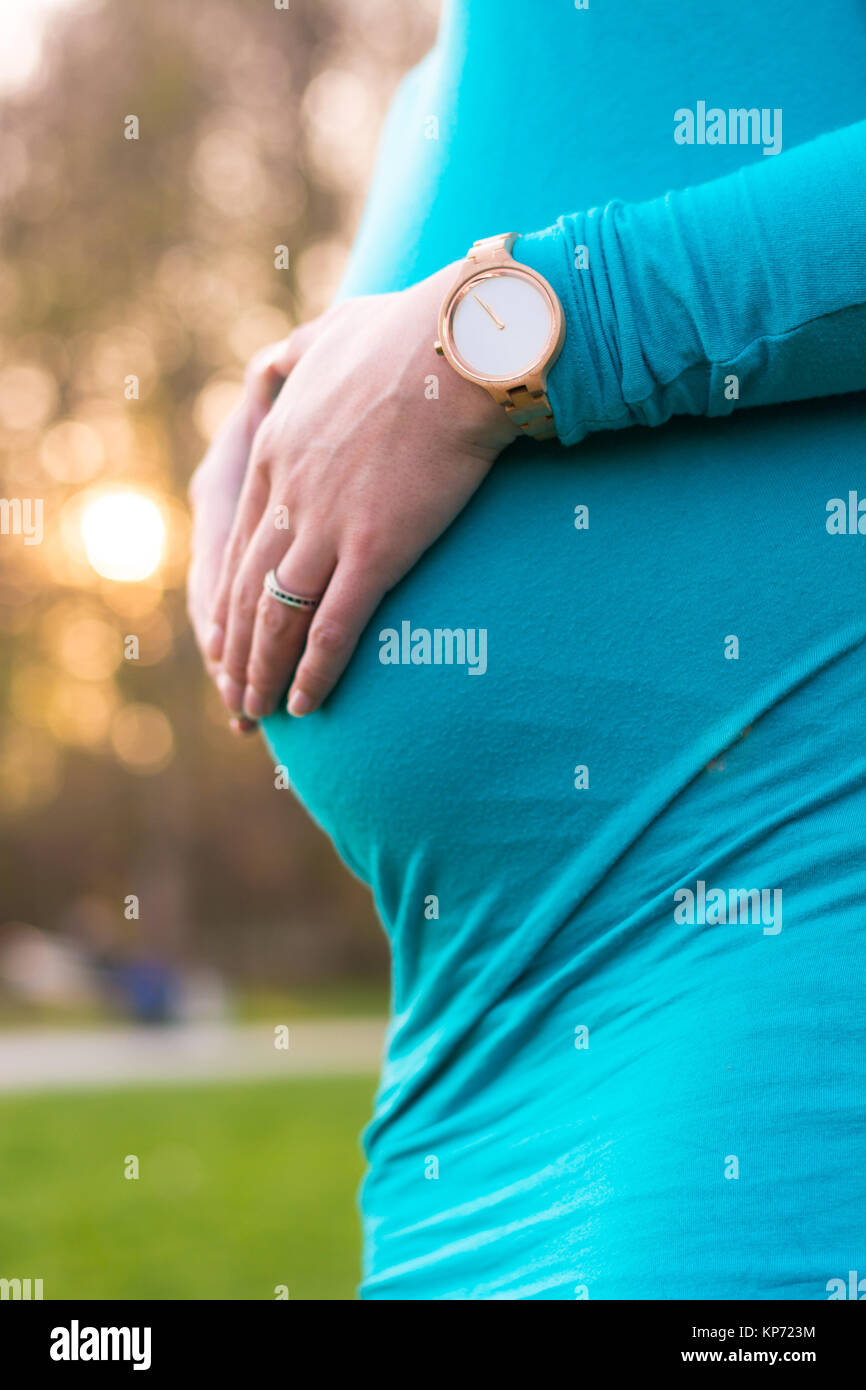Closeup of pregnant belly at sunset Stock Photo - Alamy