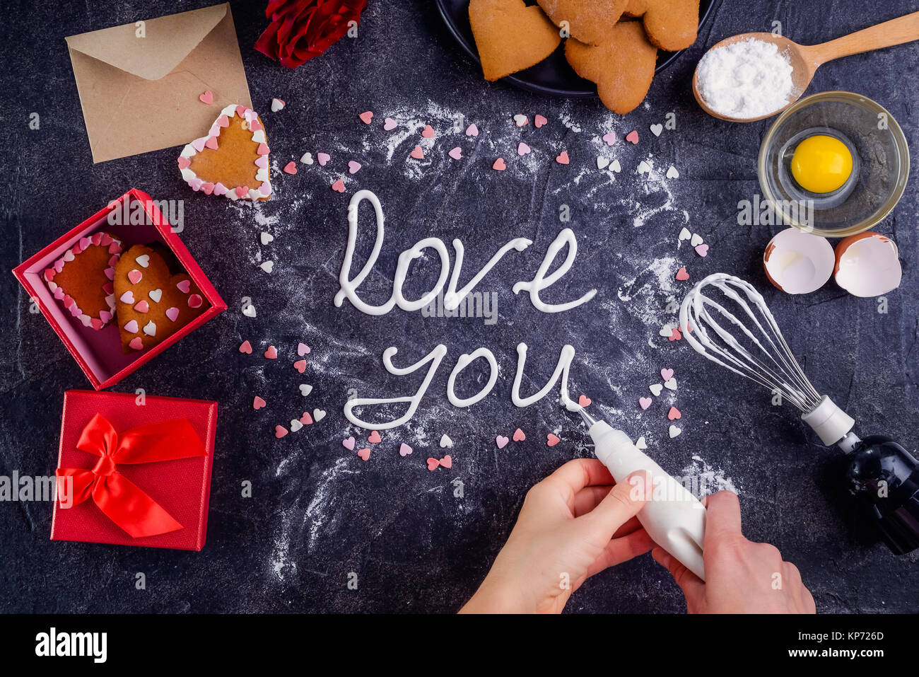 Top view woman hands making meringue cream lettering Love you on the ...