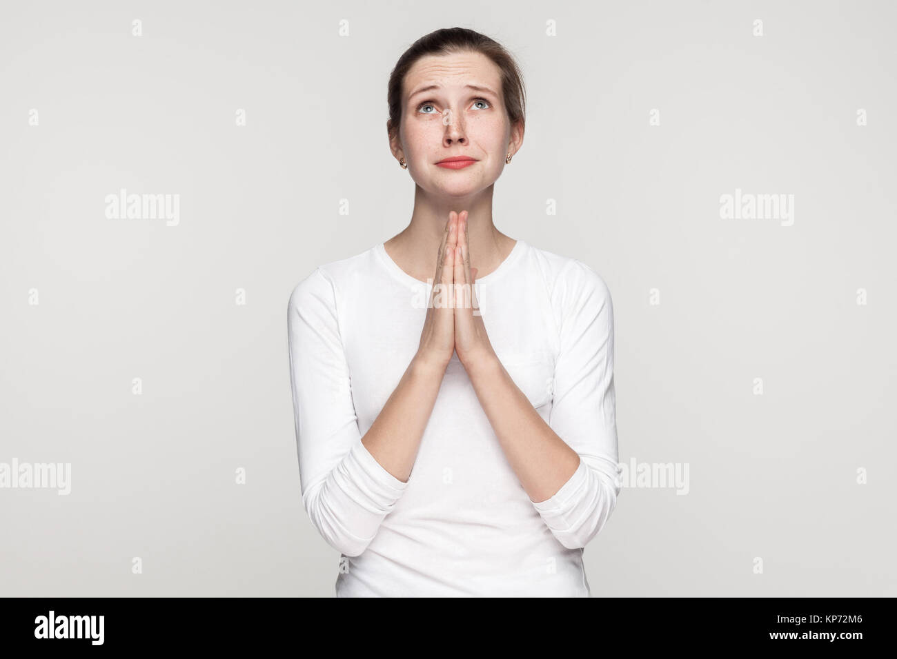 Religion concept. Prayer girl. Studio shot,isolated on gray background ...