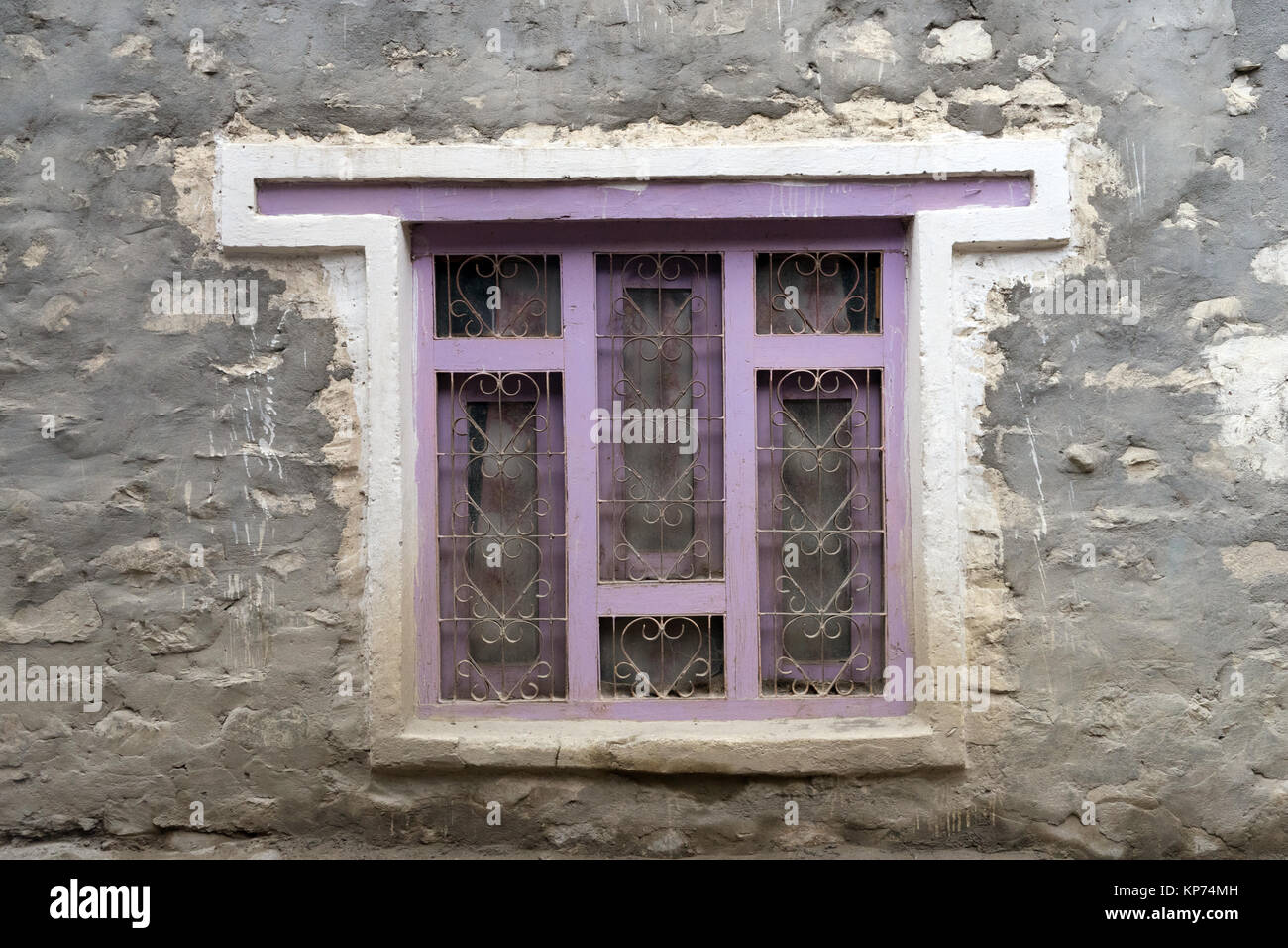 Window with purple wooden frame on the exterior wall of a Tibetan house ...