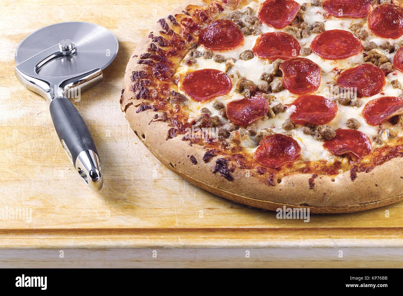 cropped image of pizza cutter and pizza Stock Photo - Alamy