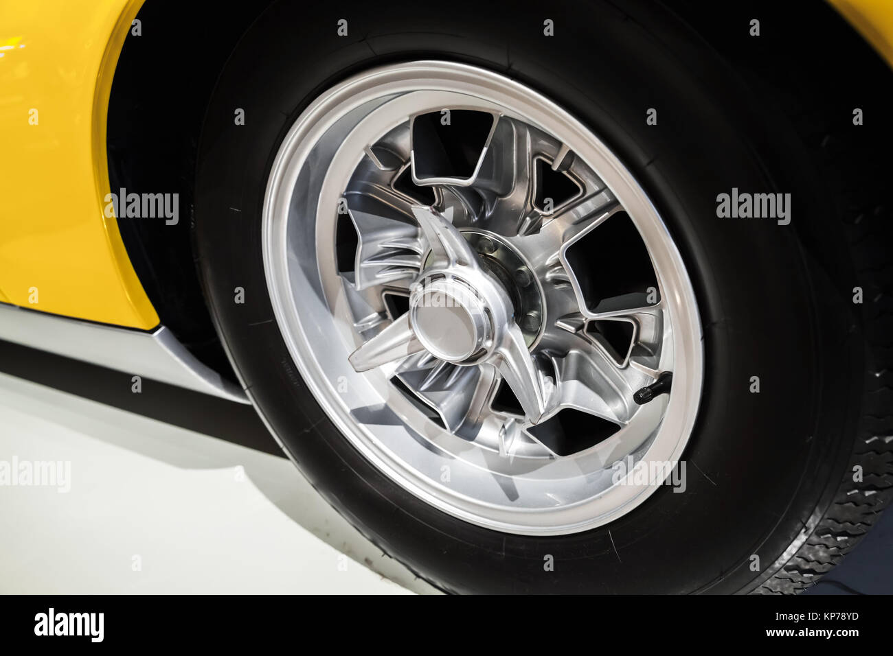 Chromed wheel disc. Yellow luxury Italian vintage sport car fragment ...