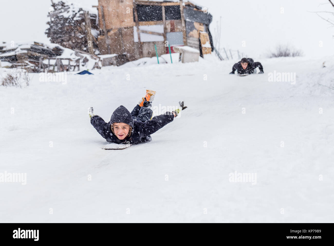 Children slide on snow in old school style with hardwood sled in ...