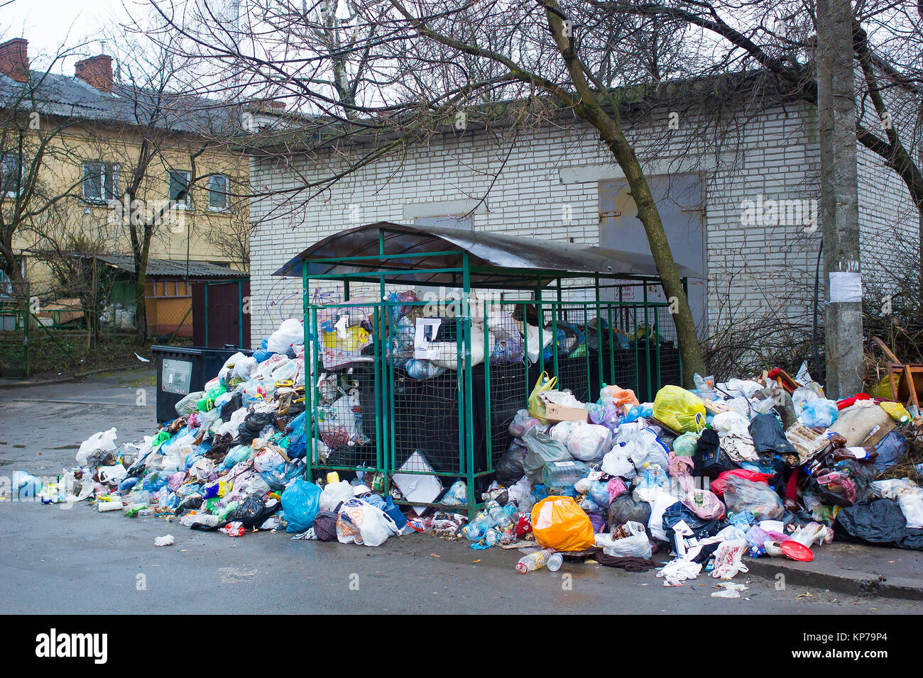 Garbage cans covered of large heap garbage on city street Stock Photo ...