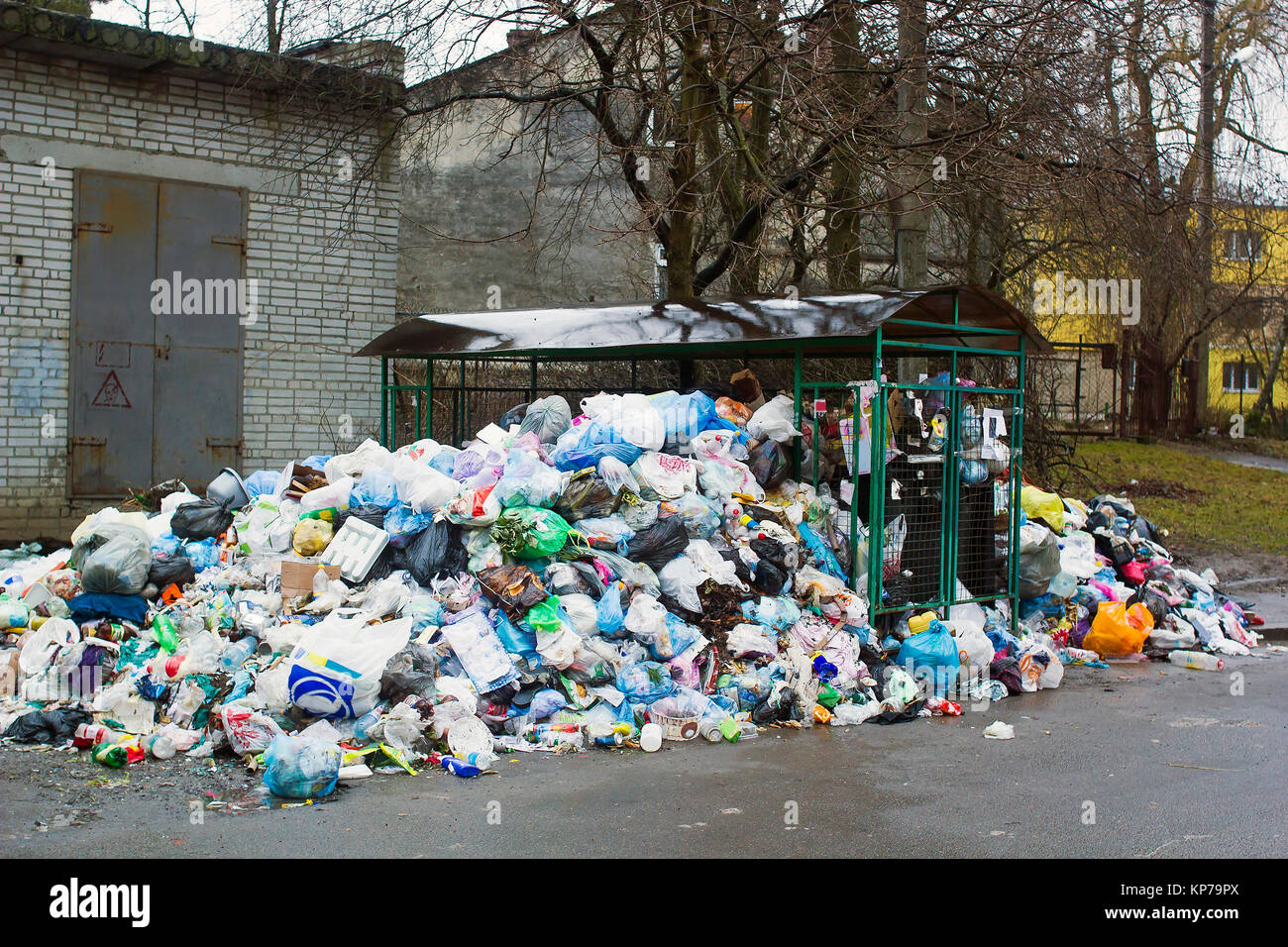 Garbage cans covered of large heap garbage on city street Stock Photo ...