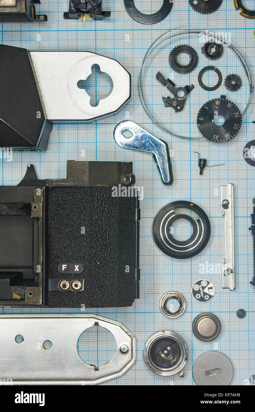 parts are completely disassembled old retro film SLR camera on graph ...