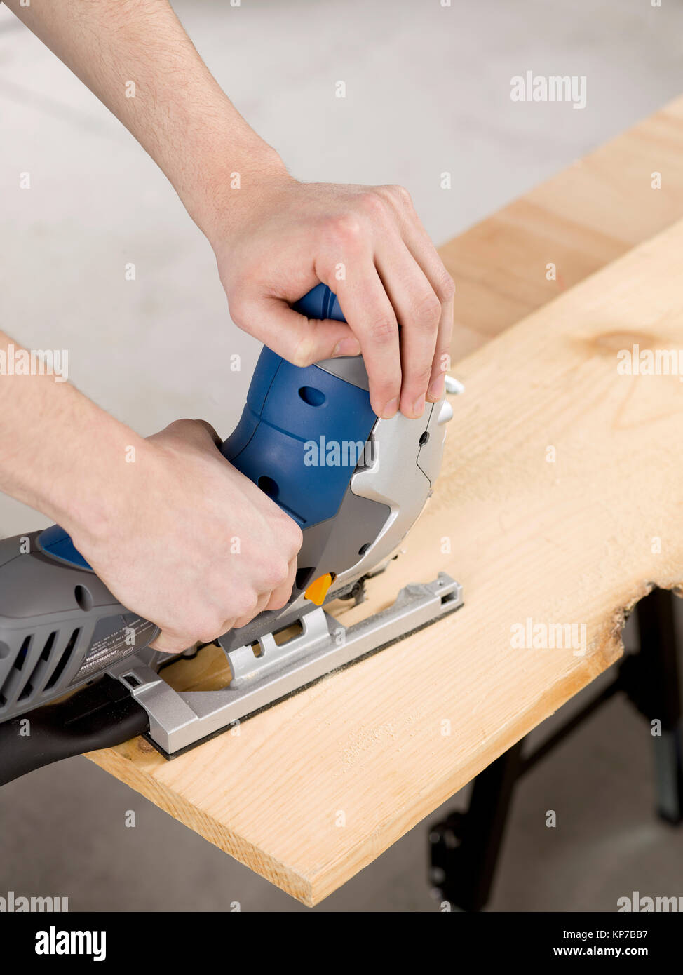 human hand holding jigsaw and cutting a piece of wood Stock Photo - Alamy