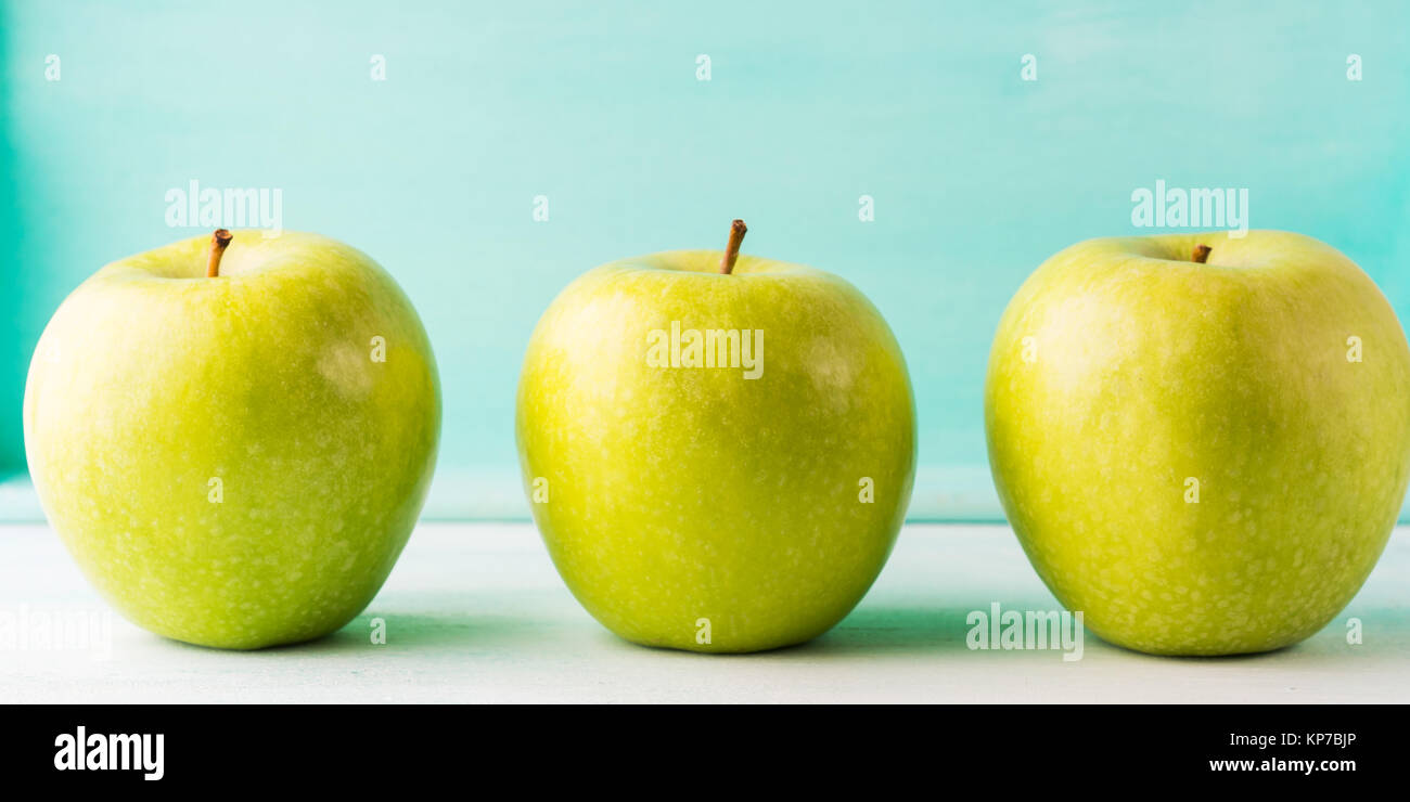 Three Green apples on turquoise background. Healthy food three pillars ...