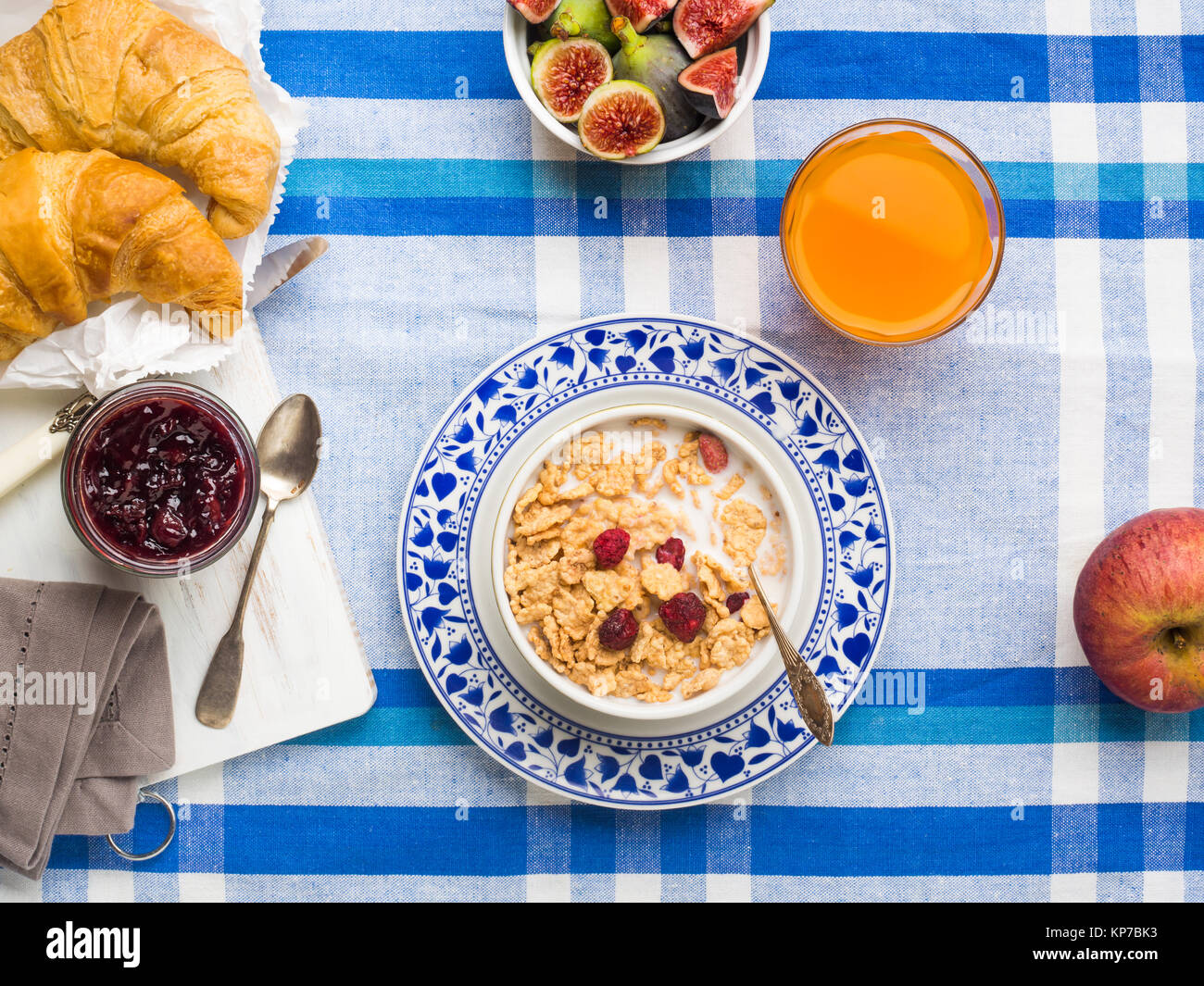 Served breakfast with cereal, figs and croissant, jam. Blue table cloth ...