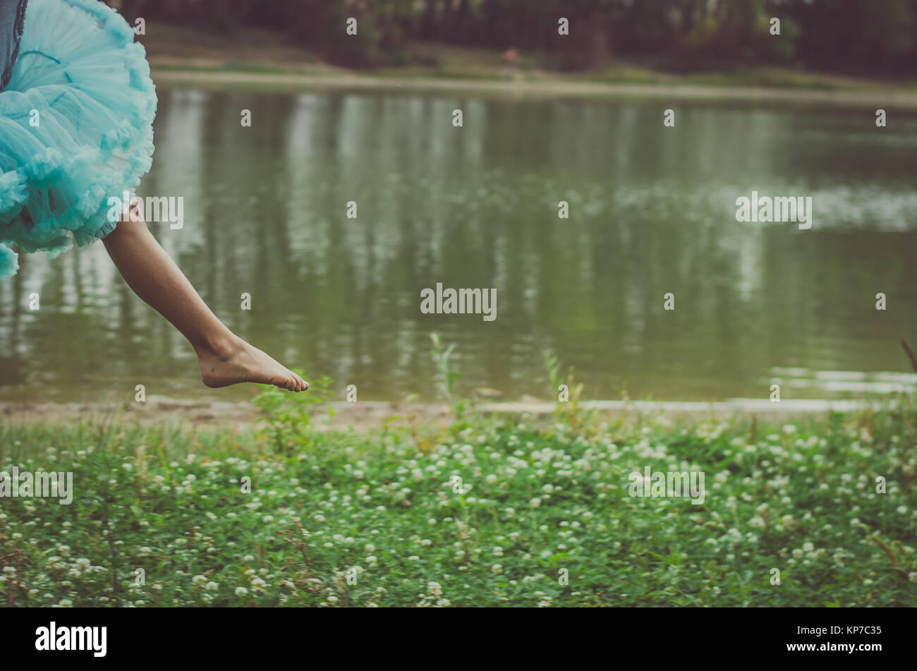 little child foot jumping into the air in the green nature in the ...