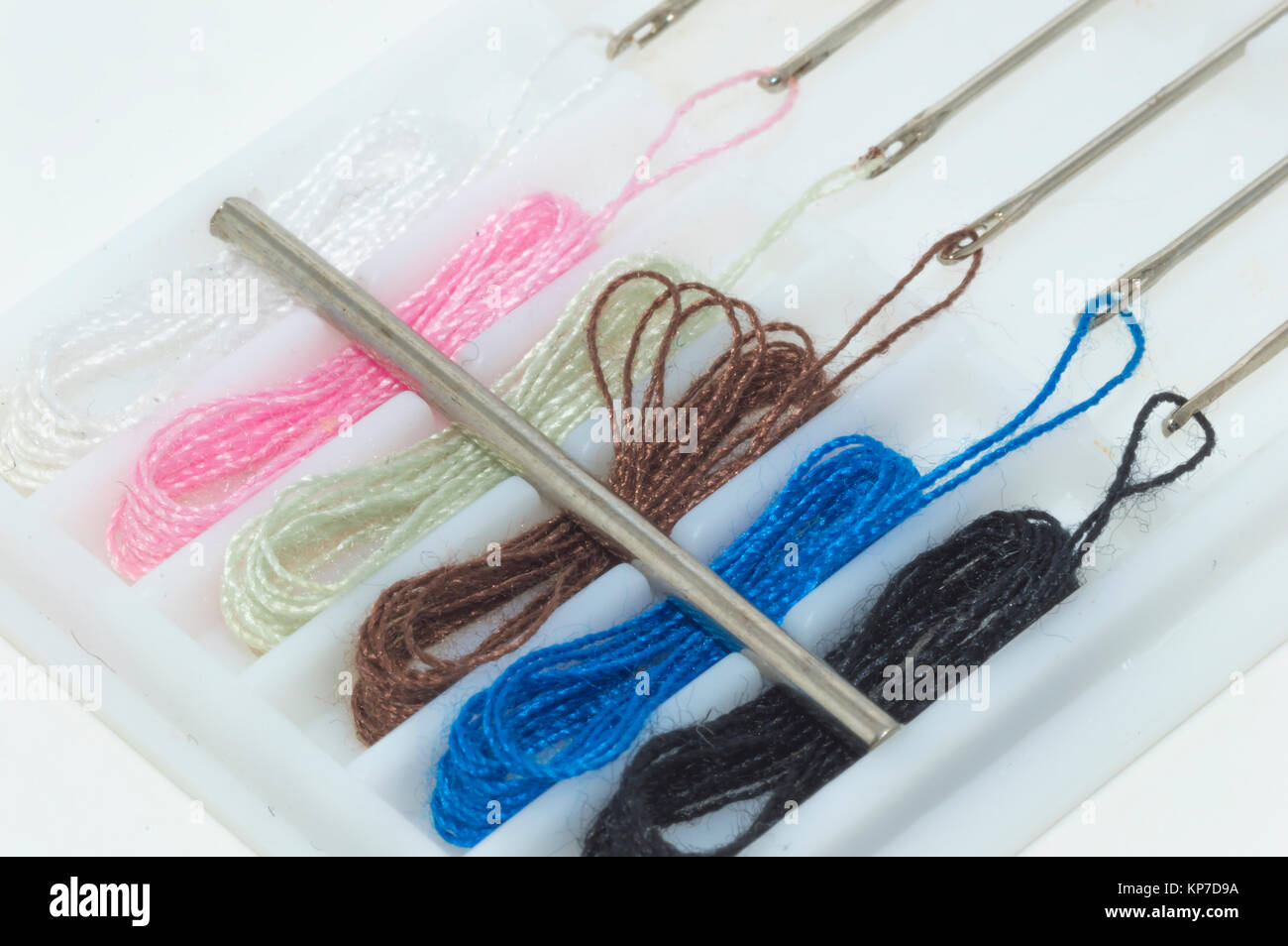 Colorful thread and needle macro with white background Stock Photo - Alamy