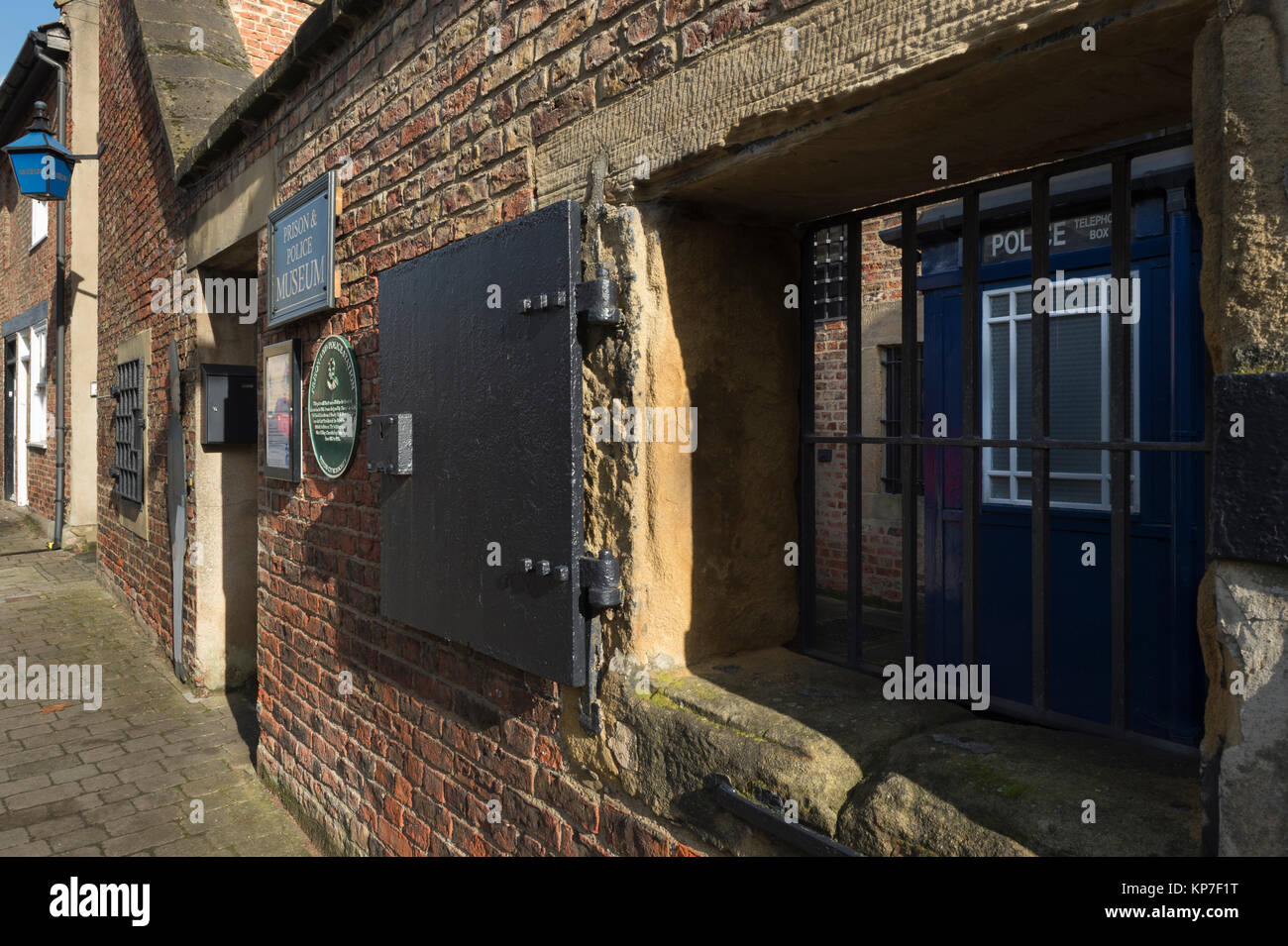 Close-up of barred window, shutter, signs & entrance to historic jail ...