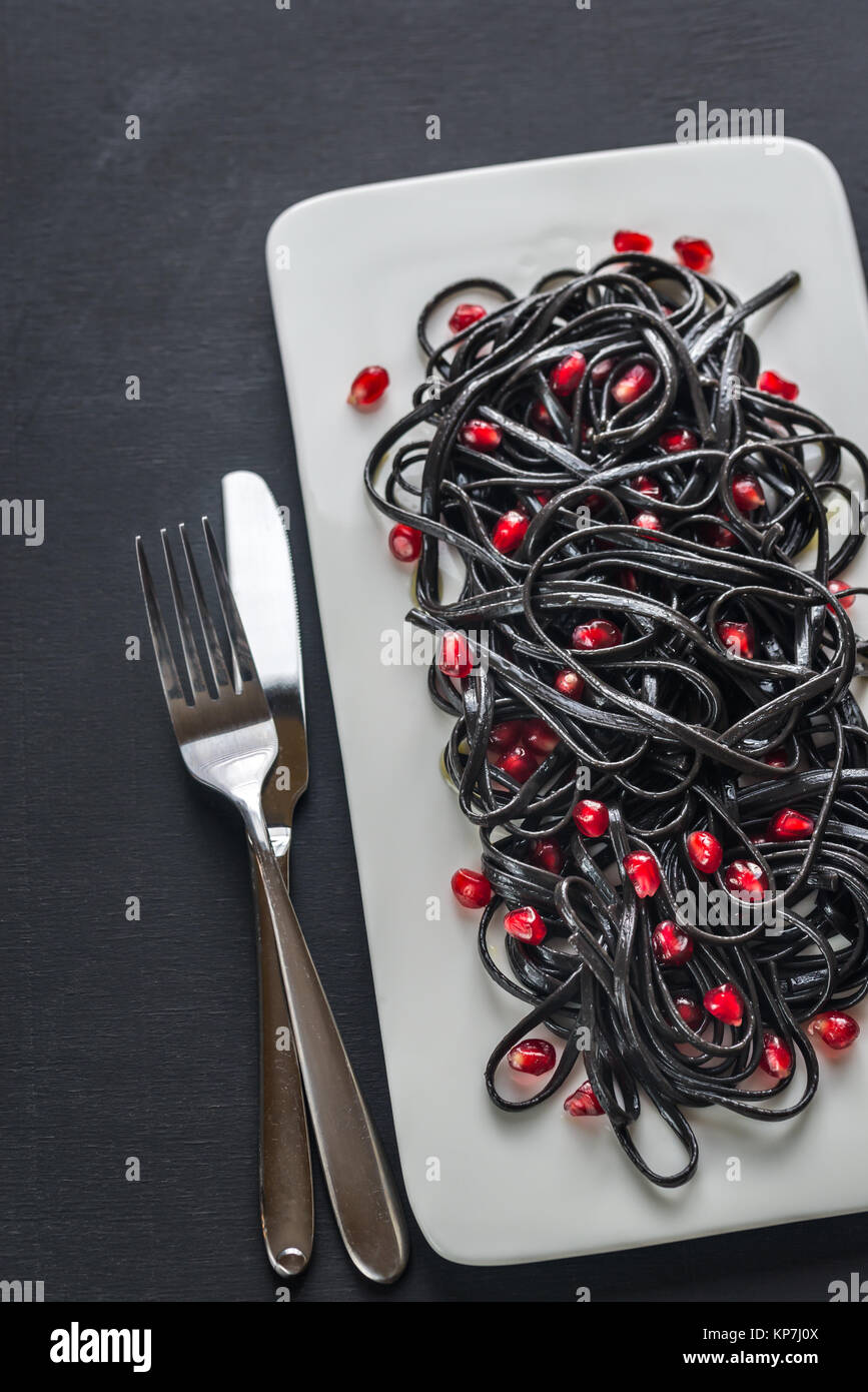 Black pasta with pomegranate seeds Stock Photo - Alamy
